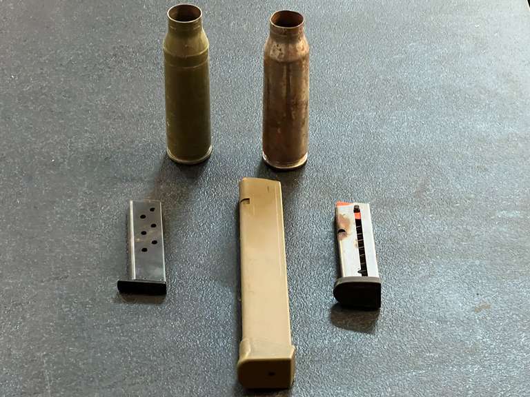 Gun magazines, three pieces, also includes two large spent shells, see ...